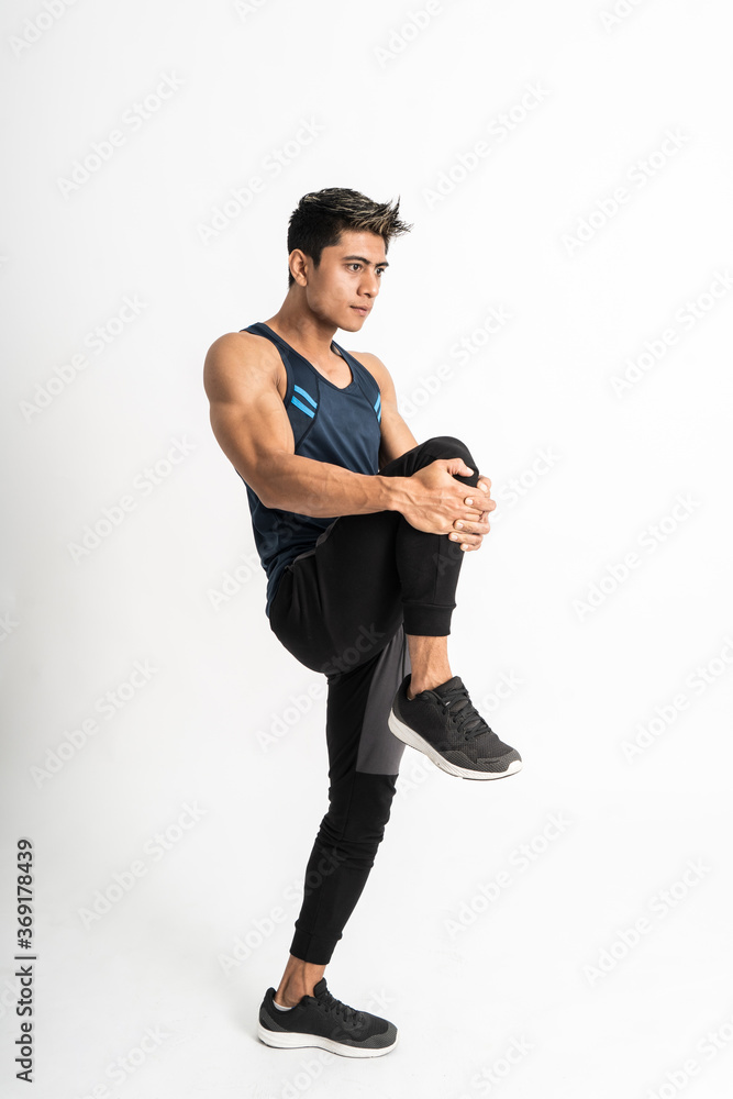 full body image of muscle man wearing sportswear stands facing side do ...