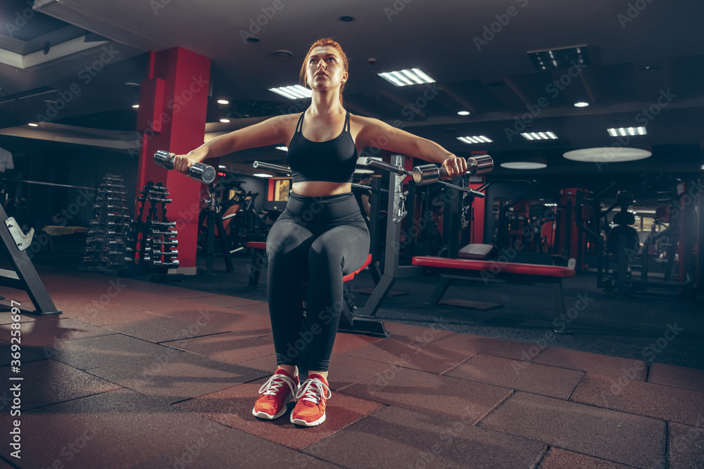 Power. Young muscular caucasian woman practicing in gym with equipment ...