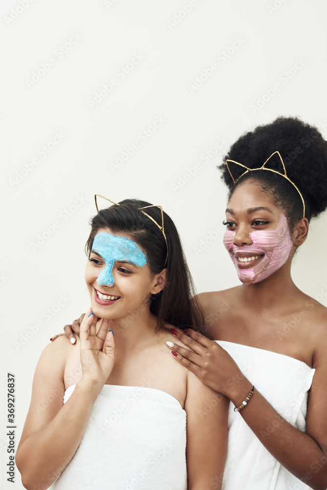 Multimasking. Two different ethnic girls are hugging. The girls' faces ...