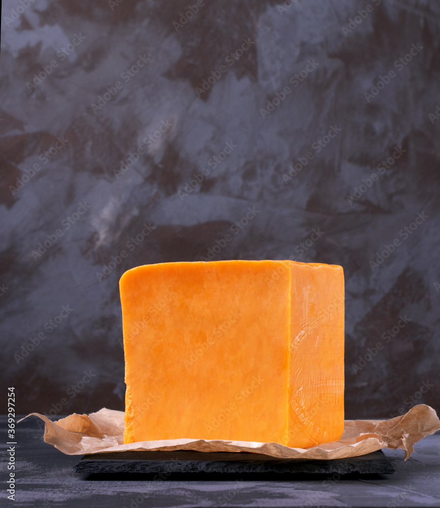 Red Cheddar cheese block against the grey background Stock Photo ...