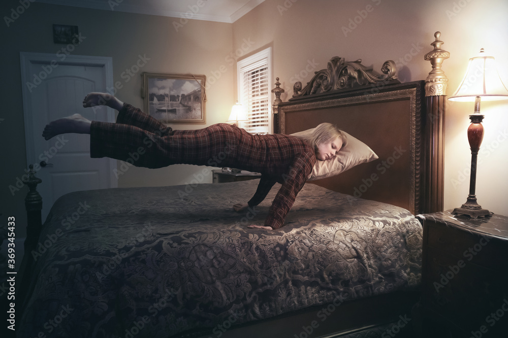 Floating woman sleeping above bed Stock Photo | Adobe Stock