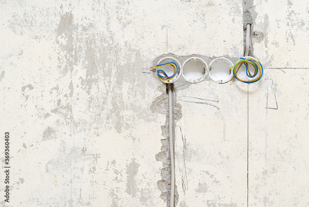 Holes in a concrete wall for installing plastic boxes under sockets ...
