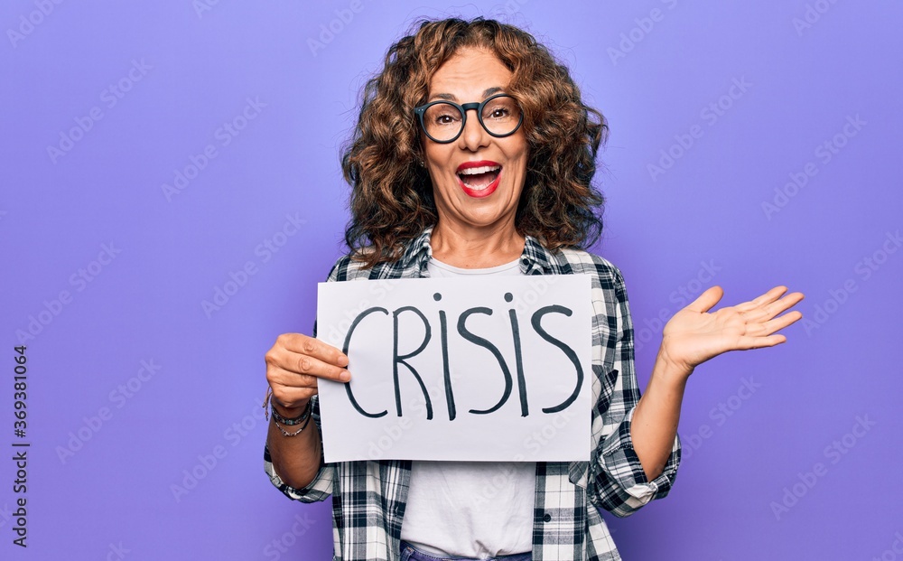 Middle age beautiful woman holding paper with crisis message over ...