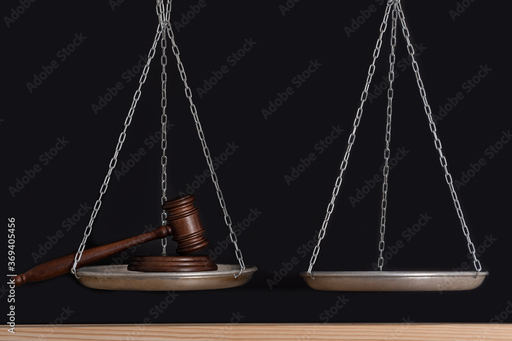 Judges gavel and balance scales, black background. Front view. Copy ...