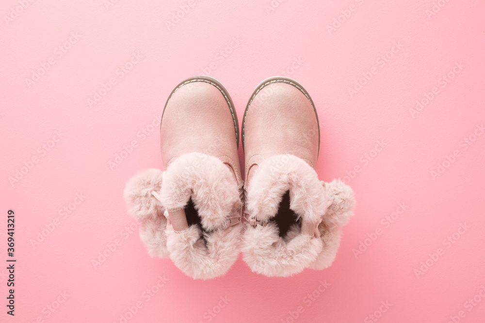 Leather warm baby boots on light pink table background. Pastel color ...
