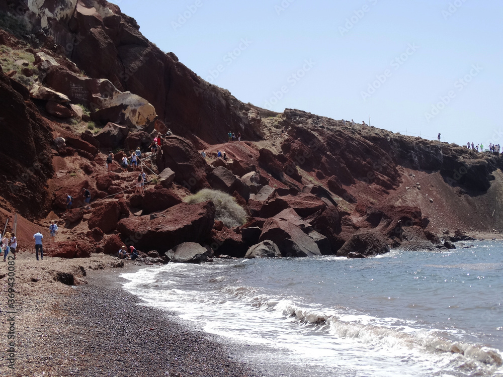 Tourists visit Red Beach in Akrotiri on Santorini Island, Greece. Red ...