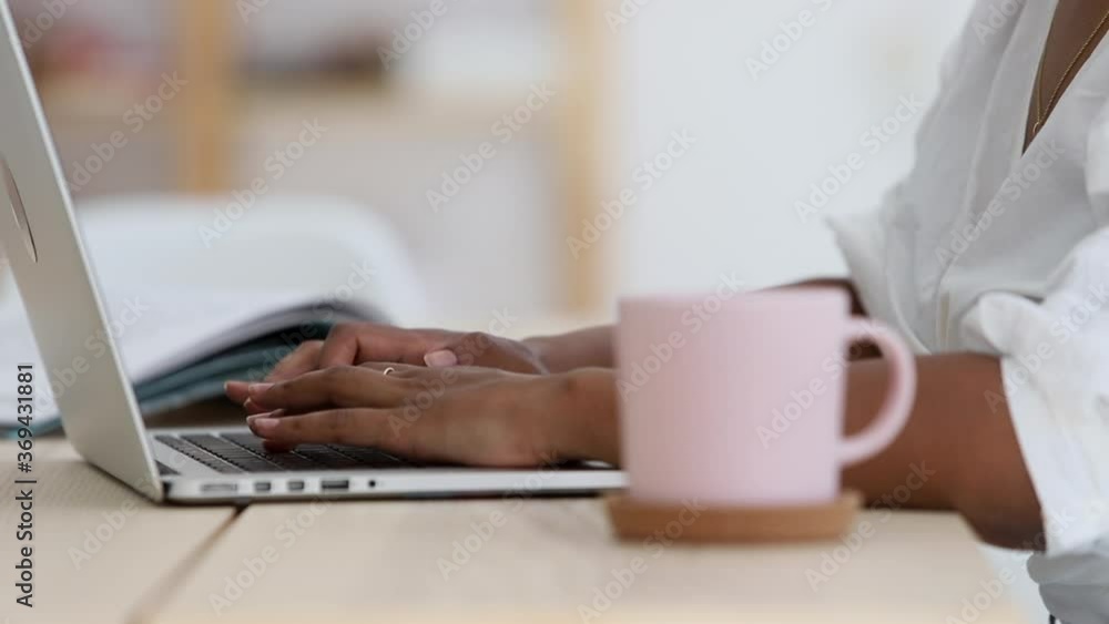 close up hands of african american girl in home office working typing ...