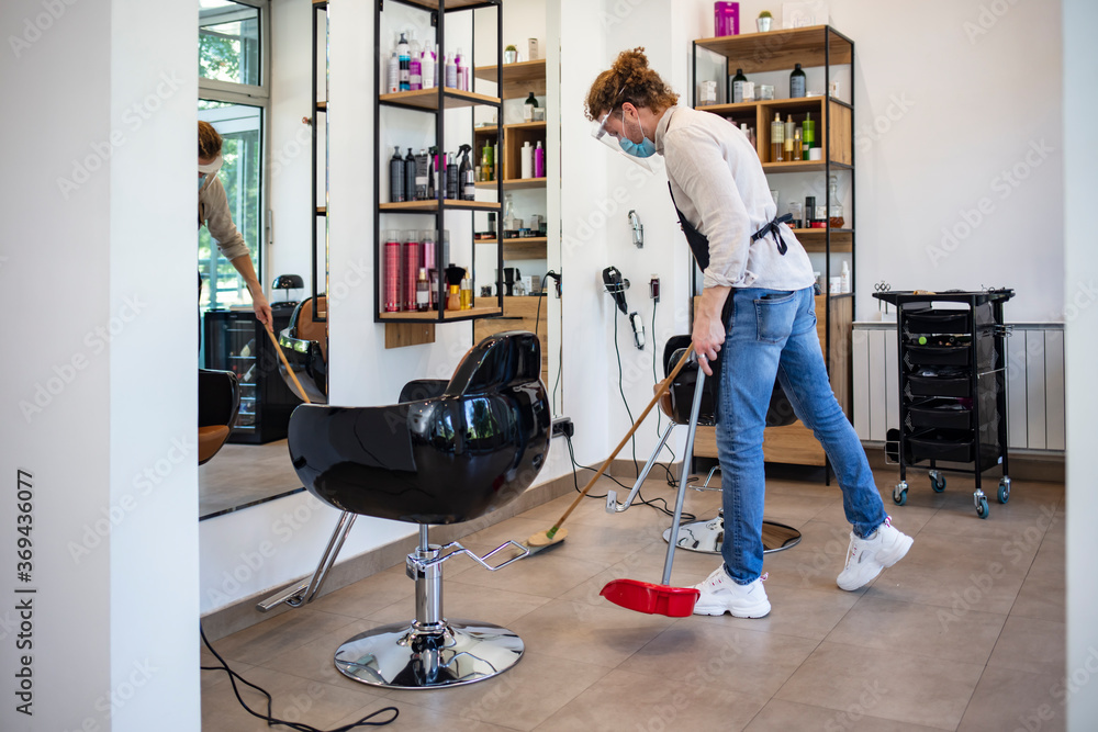 Hair stylist cleaning his work space during pandemic isolation, he ...