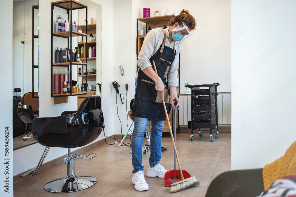 Hair stylist cleaning his work space during pandemic isolation, he ...