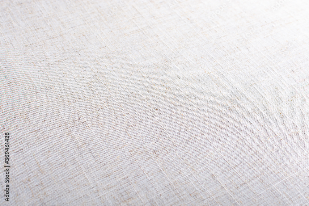 texture of light beige linen fabric at a sharp angle with selective ...