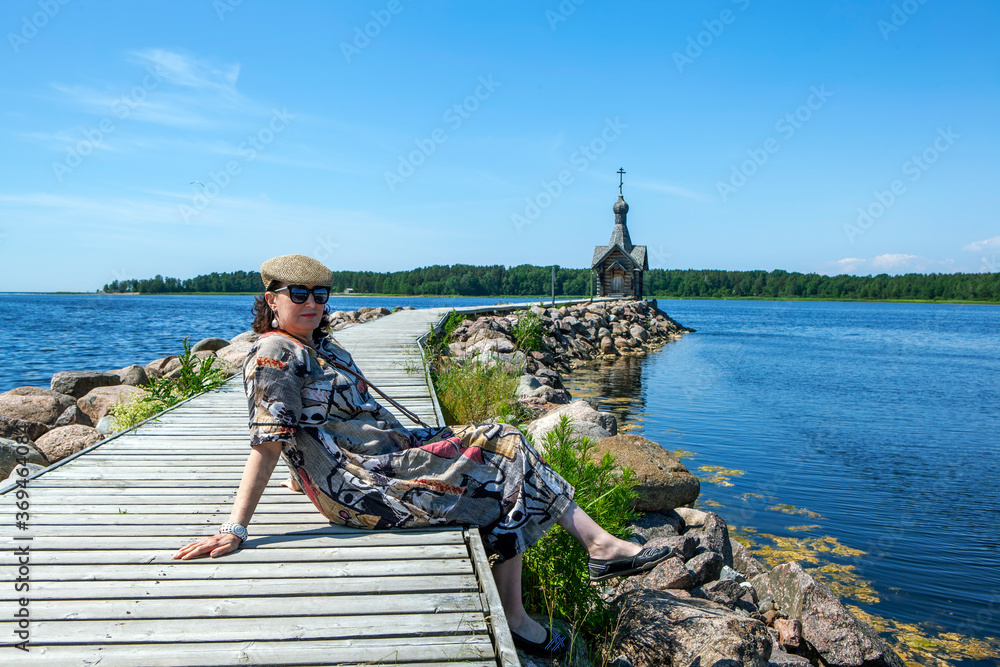 Seated woman in front of the chapel of St. Nicholas the Wonderworker ...