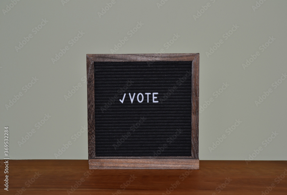 Vote message with a check mark on a felt board sign with a light green ...