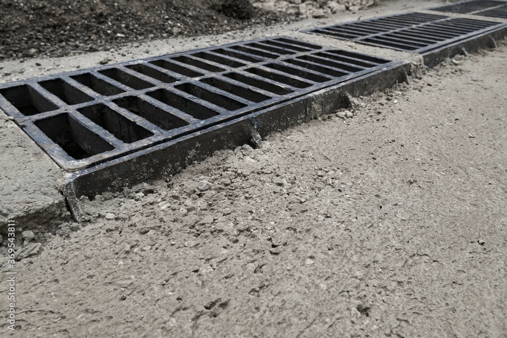 New rainwater grate on the road or sidewalk, installation in concrete ...