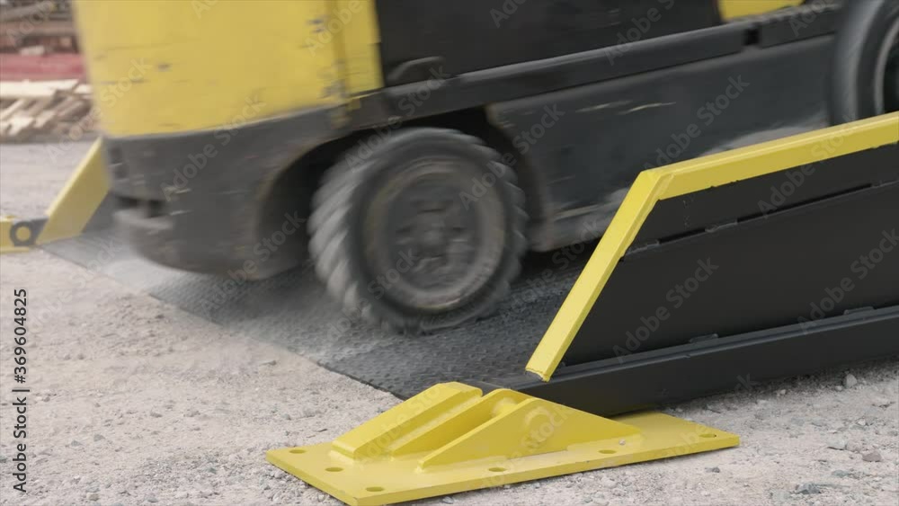 Forklift Loader Goes up Ramp To Load truck trailer equipment outdoors ...