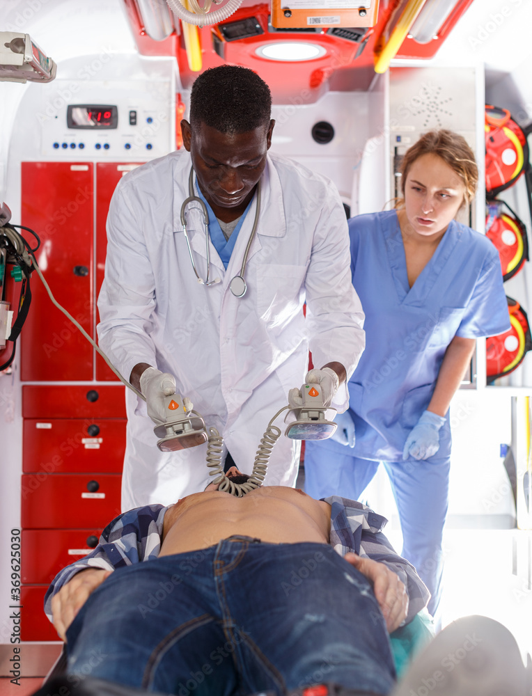 Emergency doctor resuscitating patient with help of defibrillator Stock ...