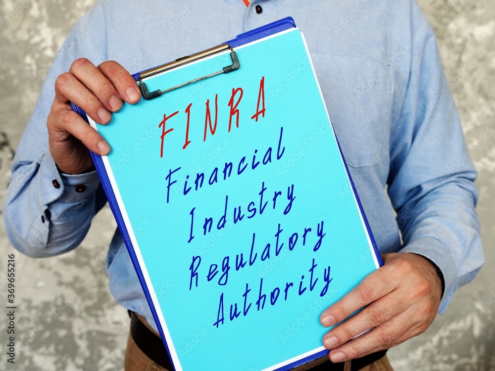 Financial Industry Regulatory Authority FINRA sign on the sheet. Stock ...