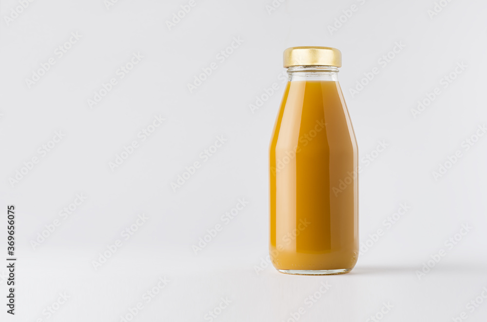 Orange mango juice in glass bottle with gold cap mock up on white ...