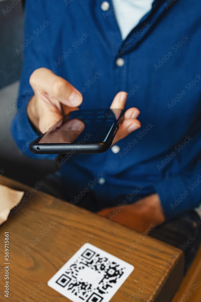 Man scanning the QR code with mobile phone Stock Photo | Adobe Stock