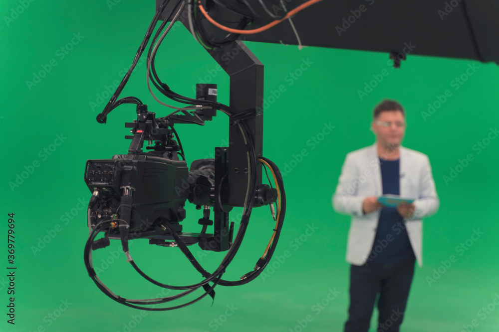 Broadcast television studio camera in greenscreen studio room with ...