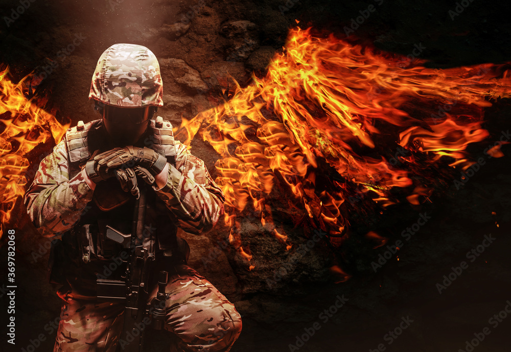 Soldier in uniform kneeling with fire wings on his back. foto de Stock ...