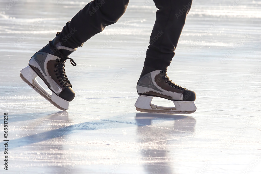 Legs of a skater on ice skating on the street ice rink. winter sport ...