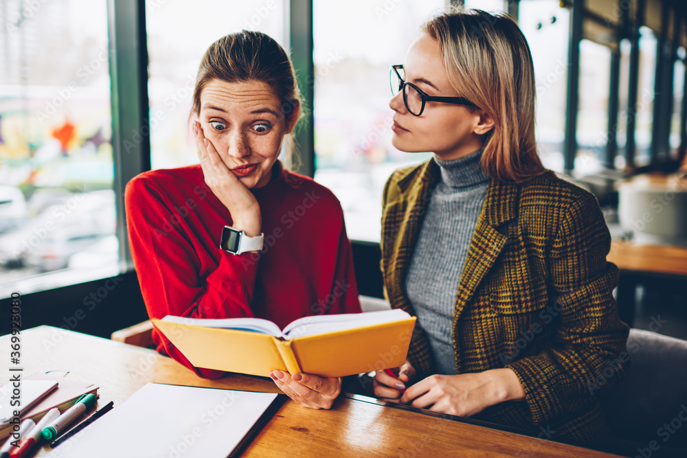 Shocked skilled student reading textbook with confused information ...