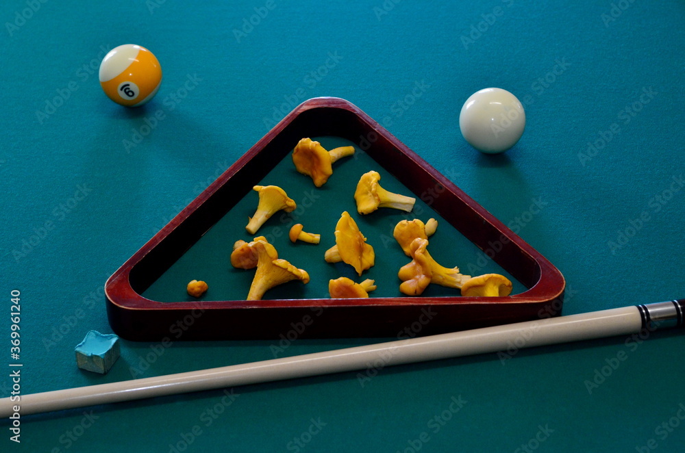 Billiard triangle with yellow chanterelles on a dark green pool table ...