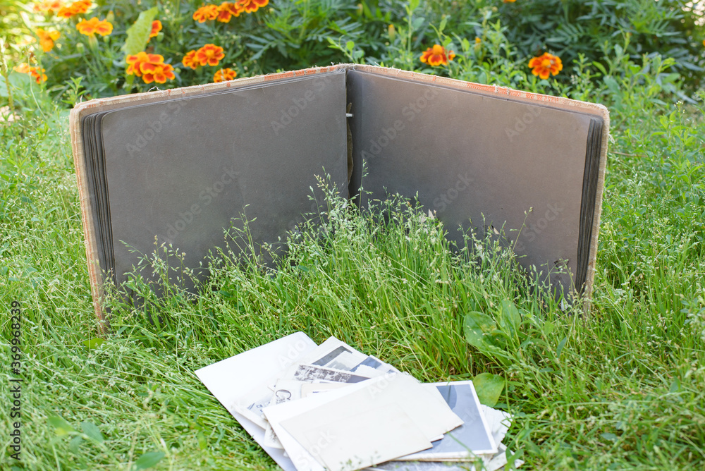 An old faded open photo album or photo book with black pages on the ...