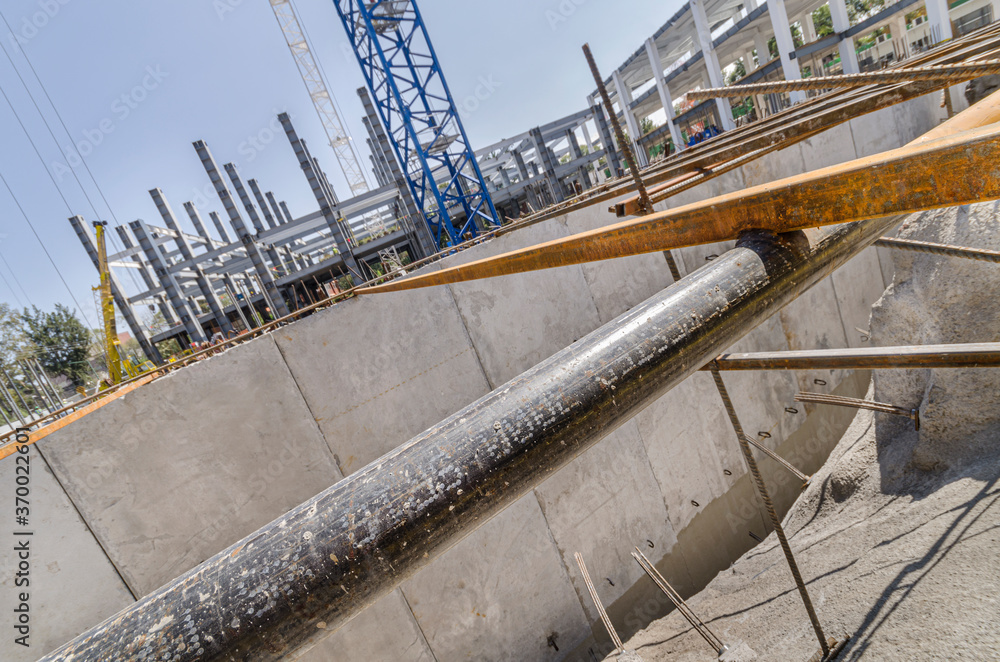 Construction site with surrounding wall or tilt-up panels and girders ...