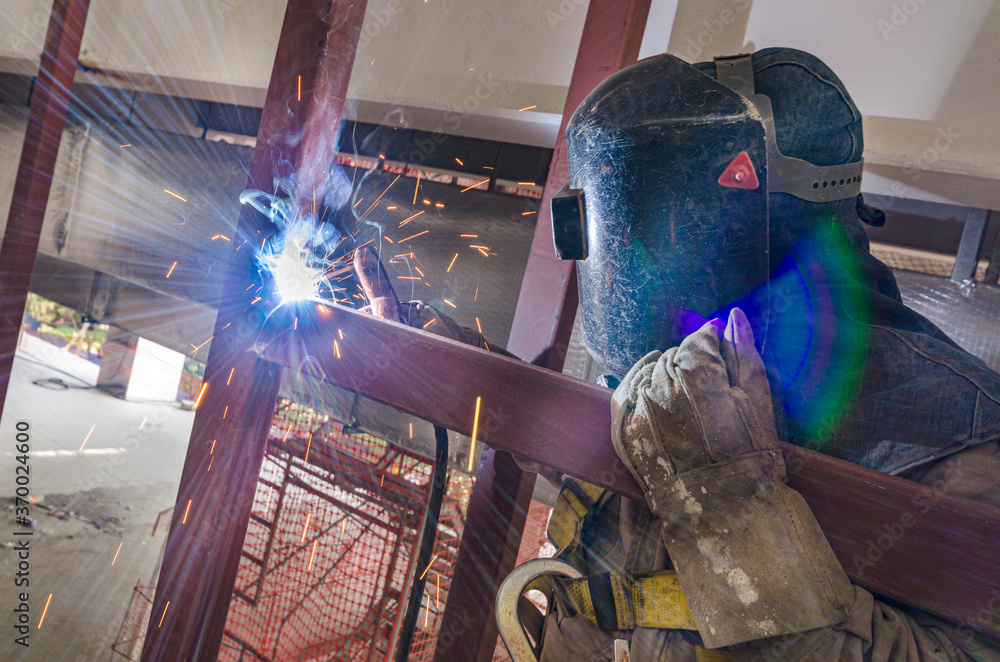 Welding metal joist Welder soldering a big metal column Stock Photo ...
