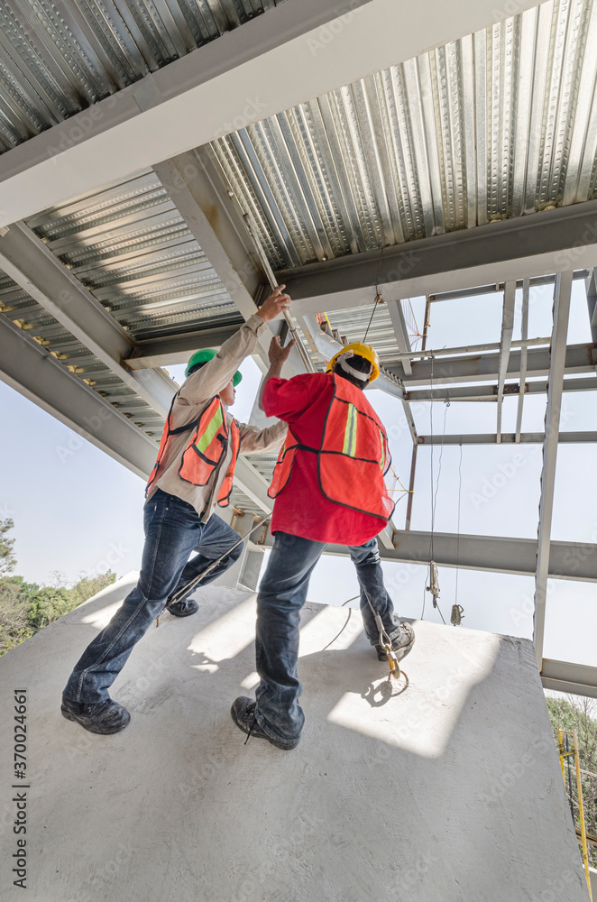 Workers raising a cemented landing stair platform in construction site ...