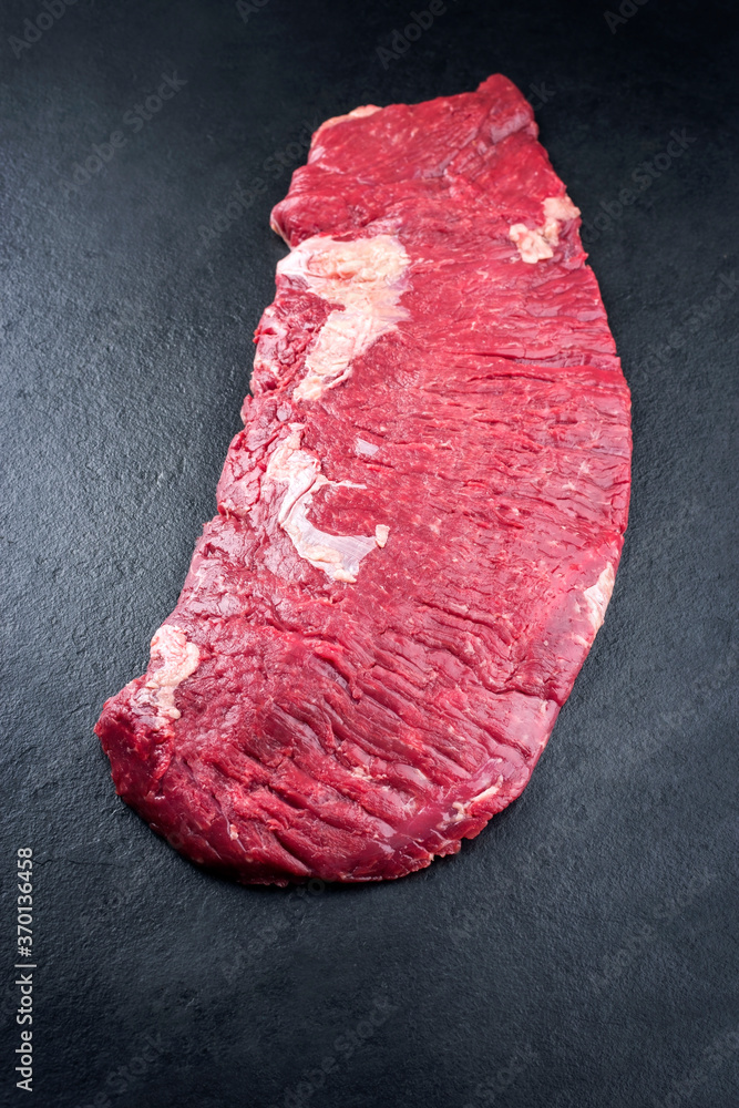 Raw wagyu top butt flap beef steak offered as top view on rustic black ...