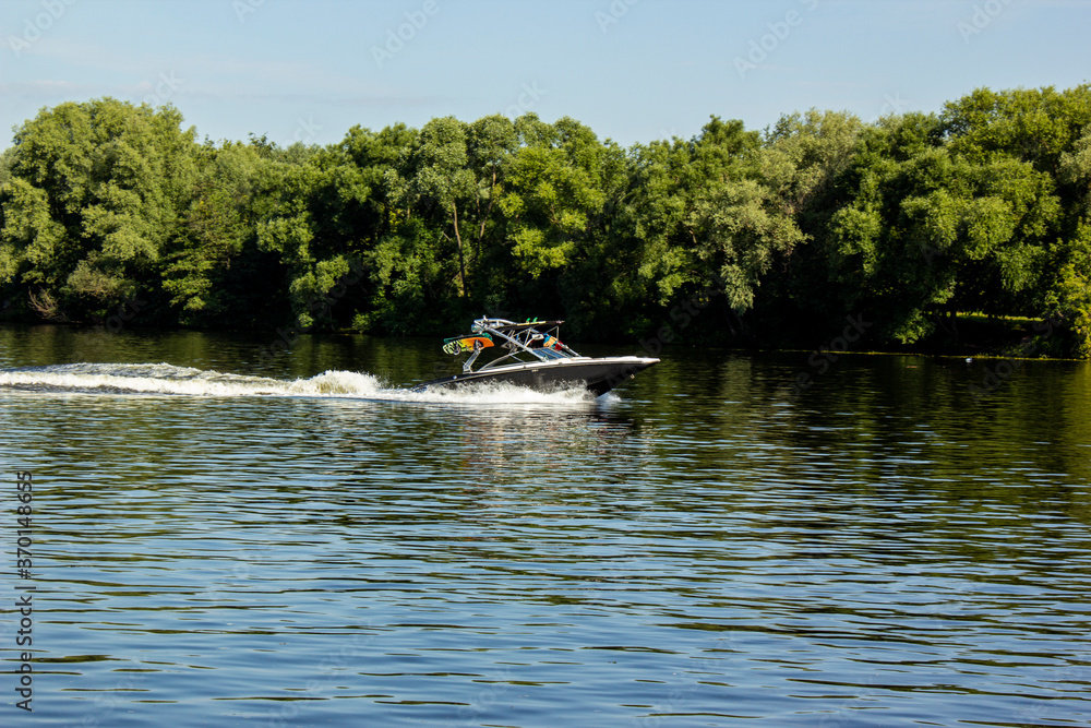 Modern speedboat sailing on forest background. Summer leisure and water ...