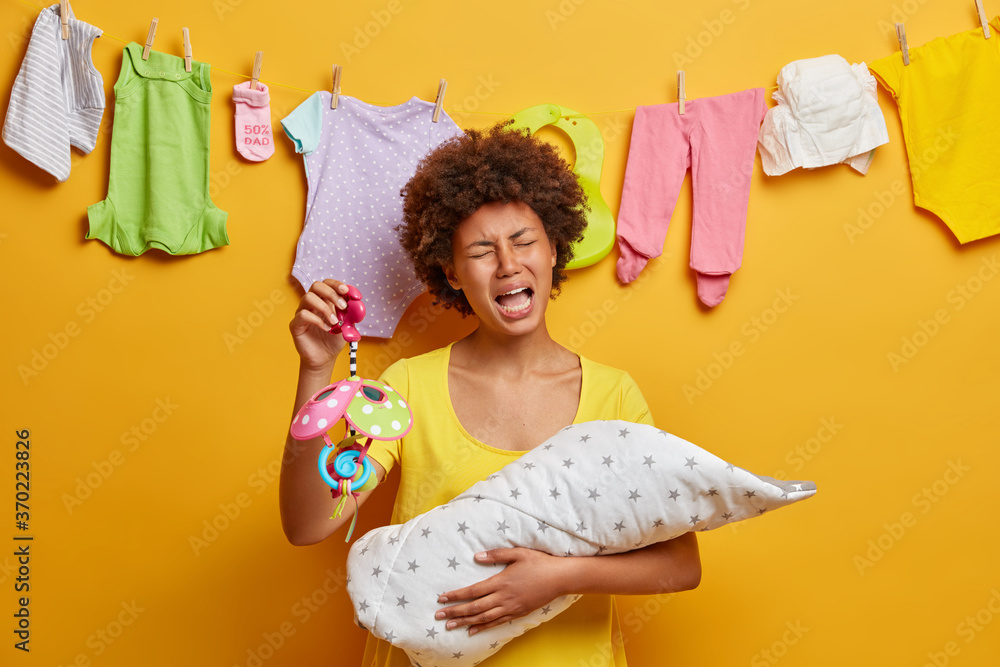 Displeased upset mother being tired of nursing baby infant, holds ...