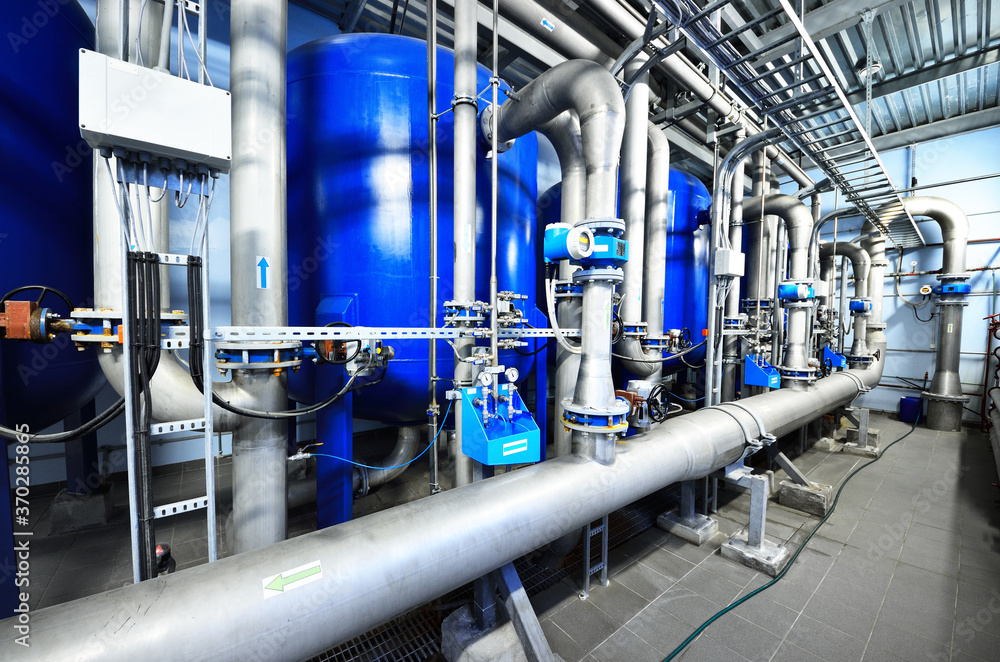 Large blue tanks in a industrial city water treatment boiler room. Wide ...