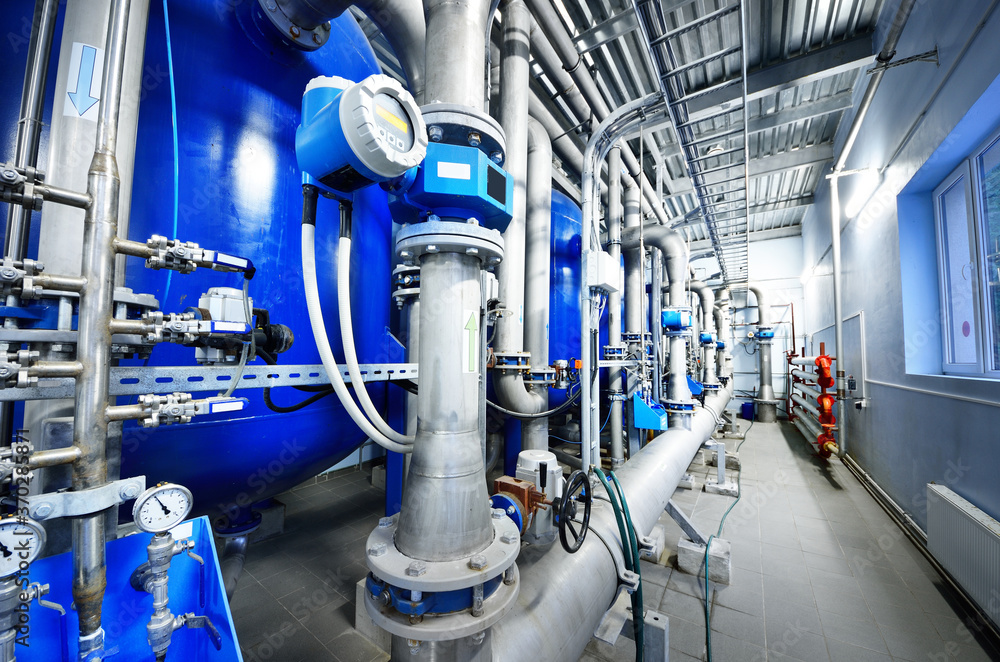 Large blue tanks in a industrial city water treatment boiler room. Wide ...