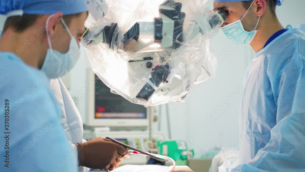Neurosurgeons in modern hospital. Surgeons use medical microscope ...