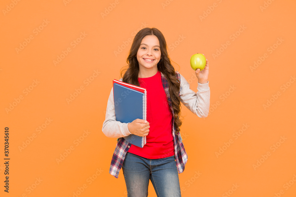 Feed your brain with knowledge. Happy kid hold apple and books orange ...