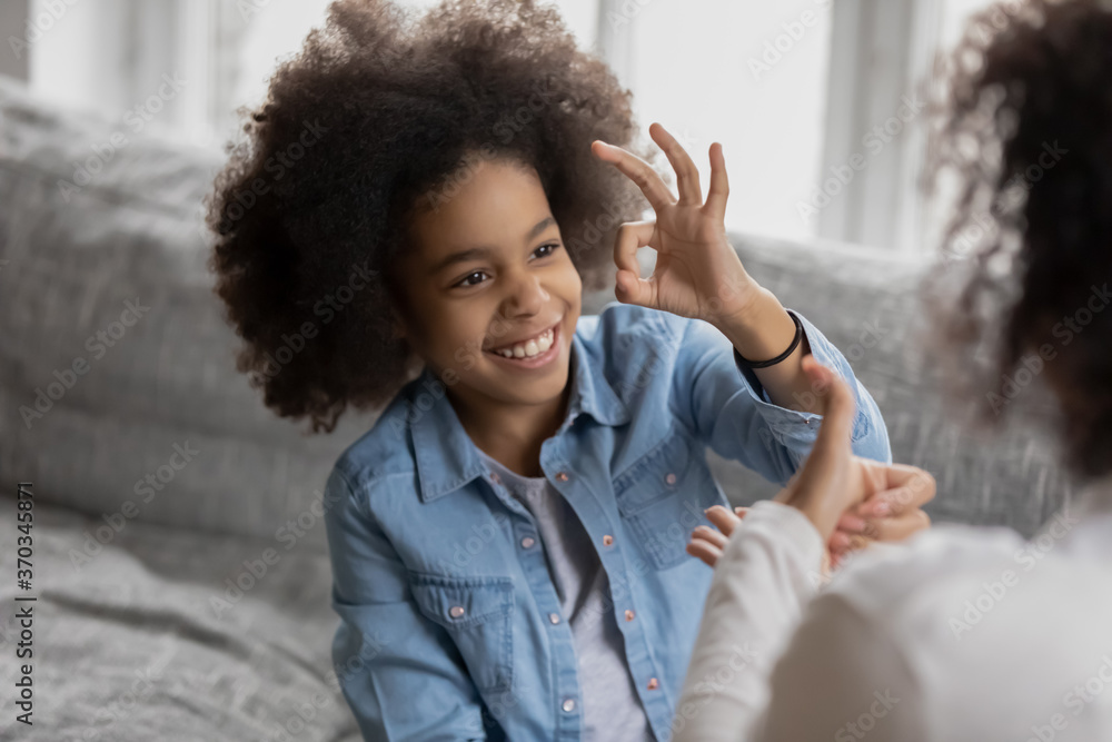 Smiling small african American deaf disabled girl show gesture with ...