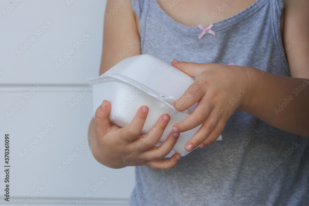 Child trying to open takeaway foam lunch box. Single use food container ...