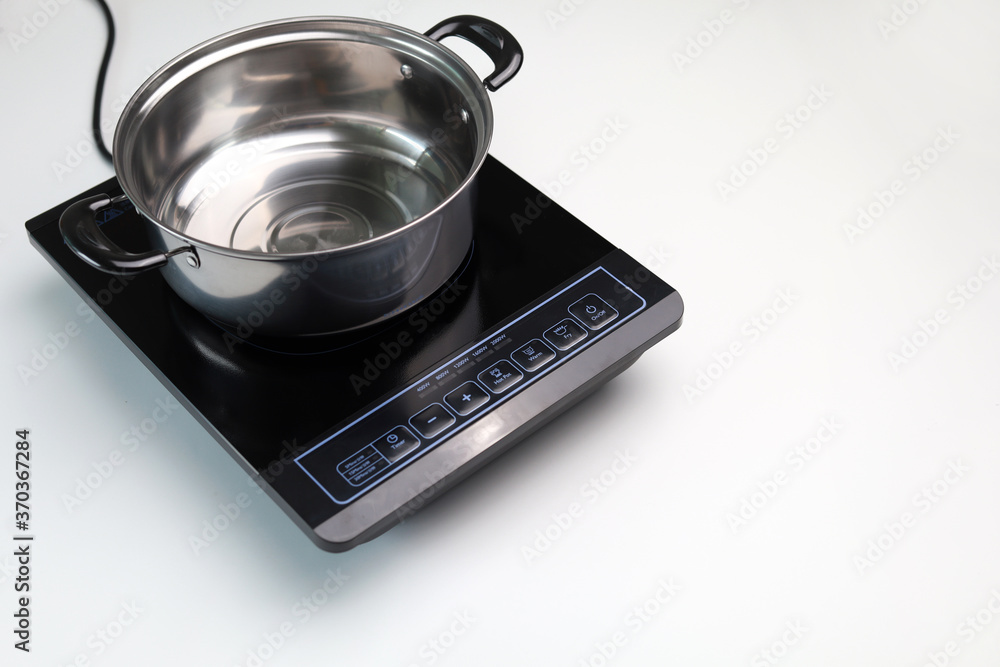 Modern stainless steel cooking pot on an induction stove. Stock Photo ...