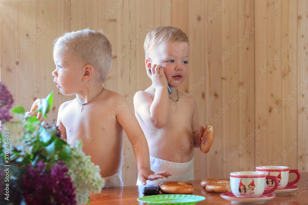 Twin boys relax in the bathhouse. Сute children’s in the sauna on a ...