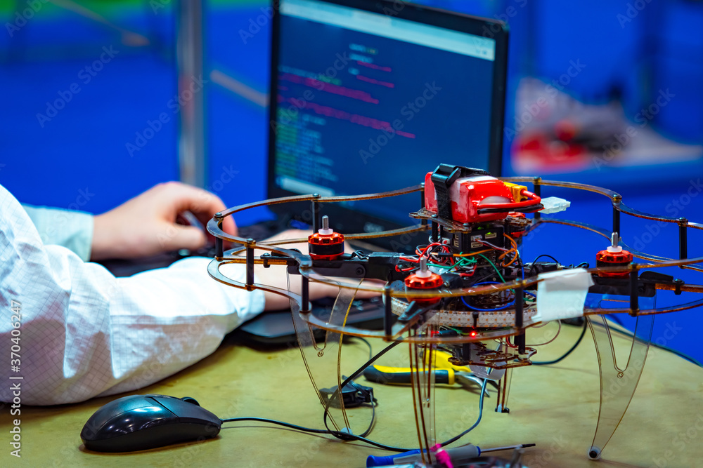 Programmable robot-a quadrocopter. The man sets the computer program ...
