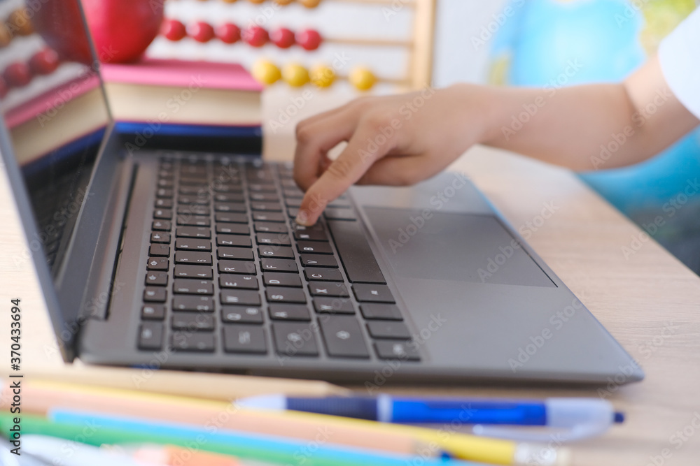 kid, boy is typing text on the laptop keyboard at his desk, next to ...