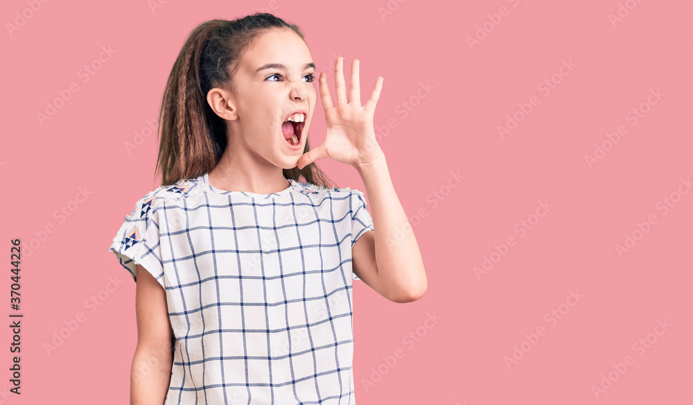 Cute hispanic child girl wearing casual clothes shouting and screaming ...