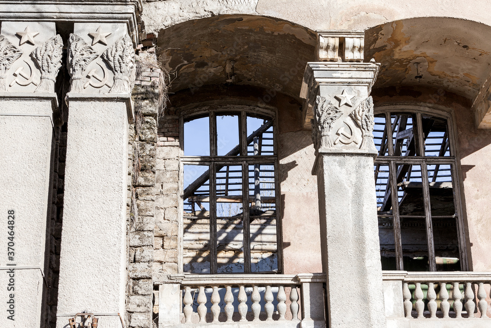 Old building falling apart with broken windows, walls covered with ...