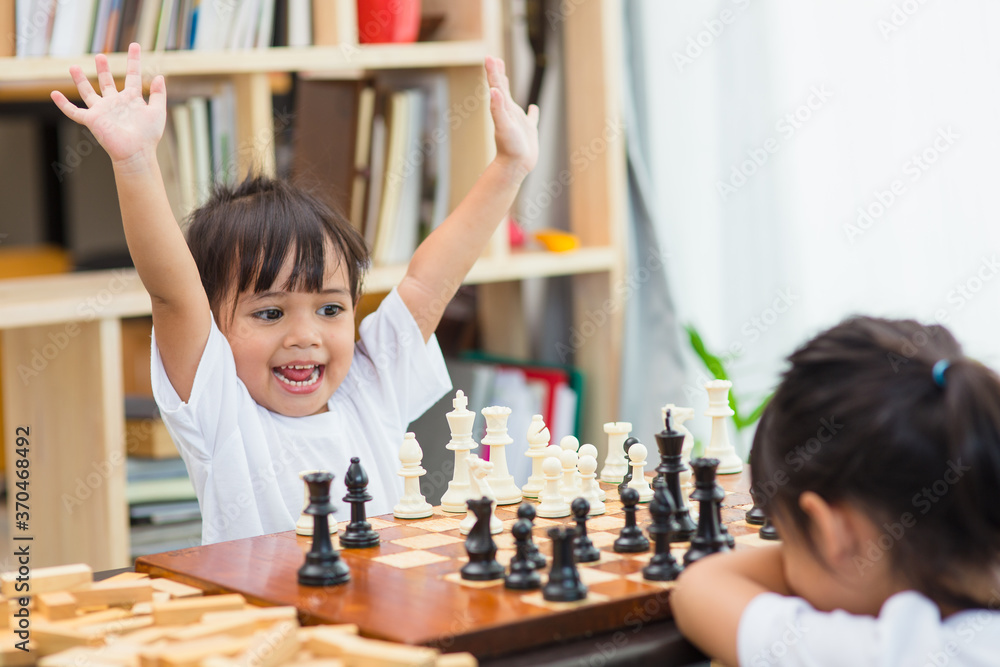 Kids playing chess - one of them just captured a pawn and celebrates ...