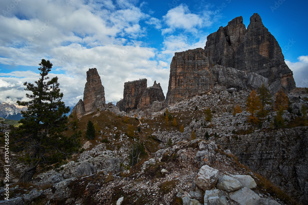 Rugged and rocky alpine mountain ranges with cloudy blue sky above in ...