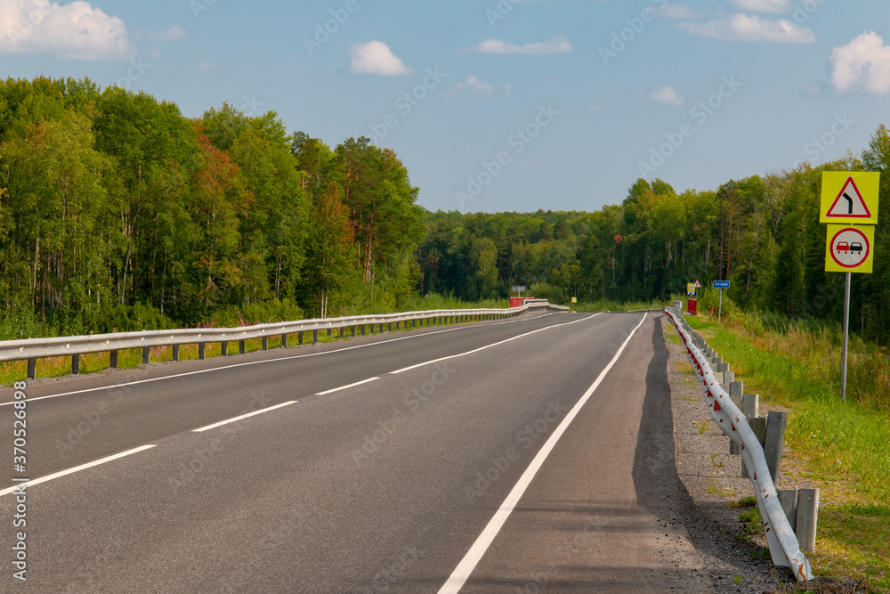 No overtaking - tight turn! Signs on the side of a two-lane highway - a ...