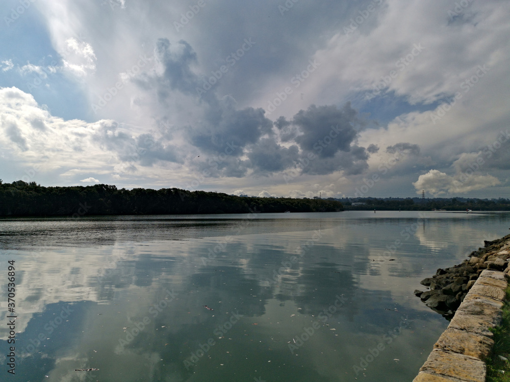Beautiful afternoon view of a river with reflections of sun, blue sky ...